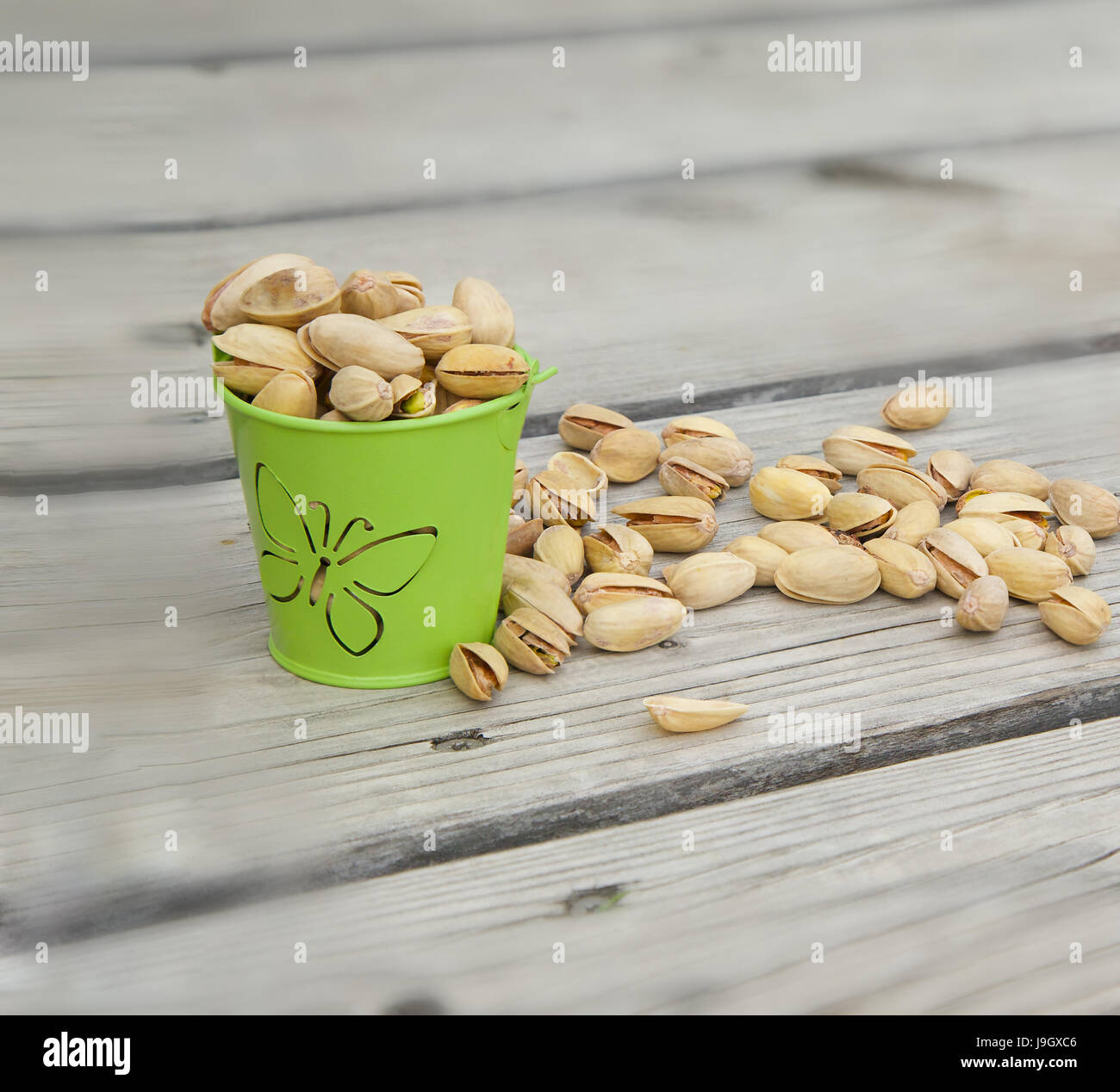 Pistachio nuts in a green decorative bucket Stock Photo - Alamy