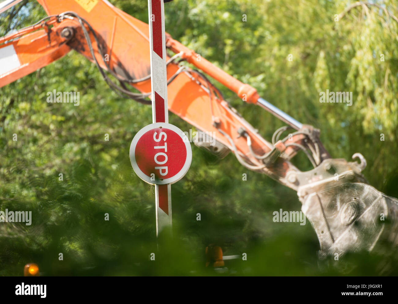raised red and white barrier stop sign, in foreground blurred green ...