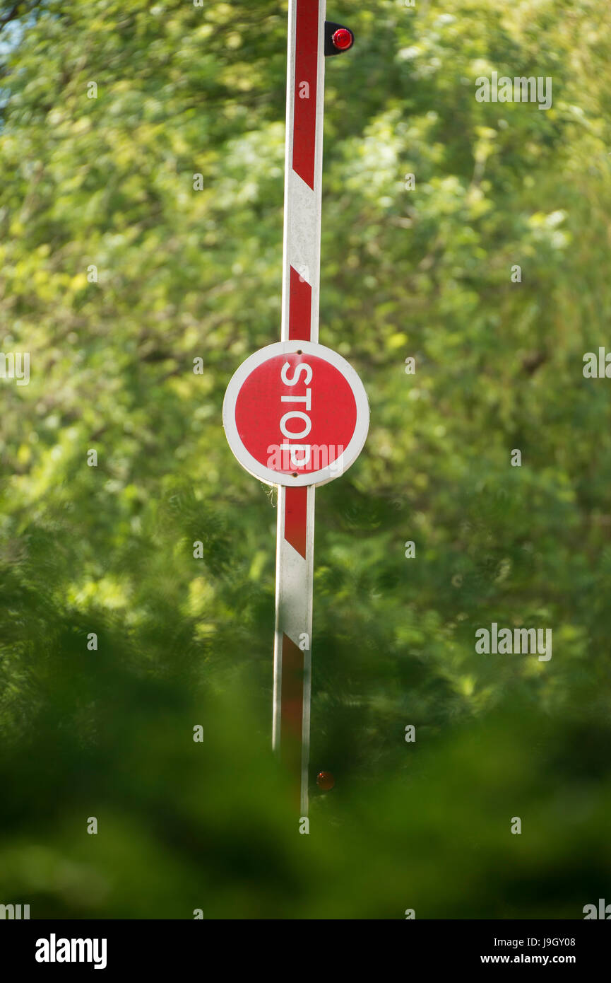 raised red and white barrier stop sign, in foreground blurred green ...