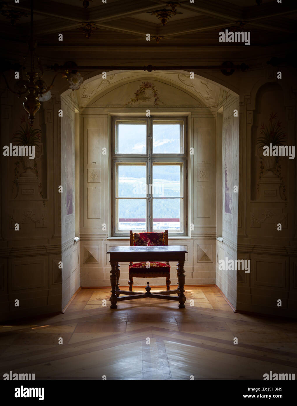 A solitaire chair and table in an ampty room of Castle Savoia, building ...