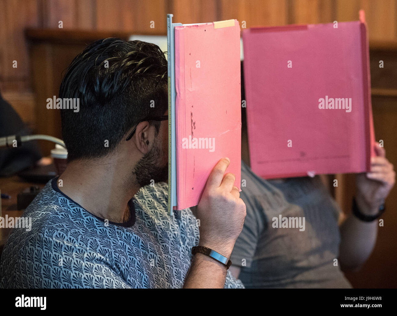 The two defendants Ahmet K. and Hakan C. hide their faces behind ... The two defendants Ahmet K. and Hakan C. hide their faces behind ...