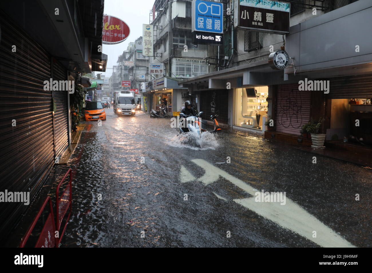 Taipei, Taiwan. 2nd June, 2017. A scooter drives down a flooded back ...