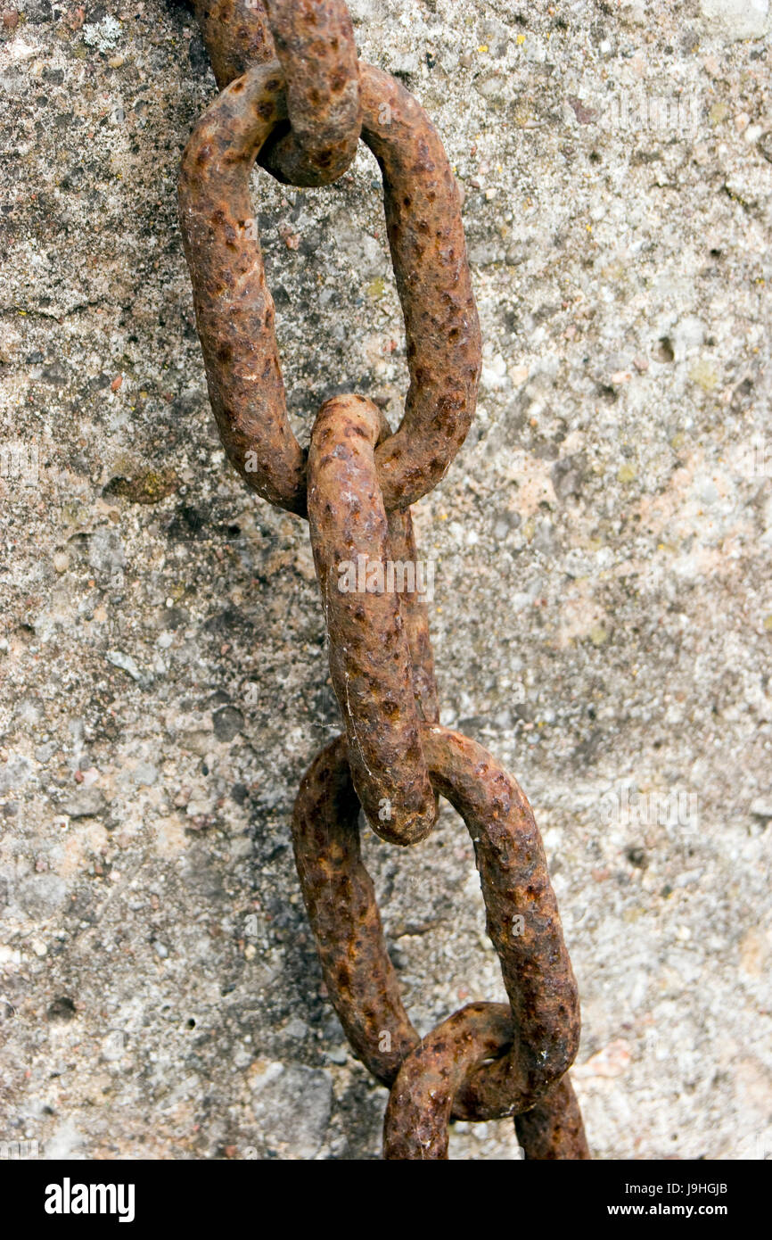 Thick rusty metal chain hanging on stone wall Stock Photo - Alamy