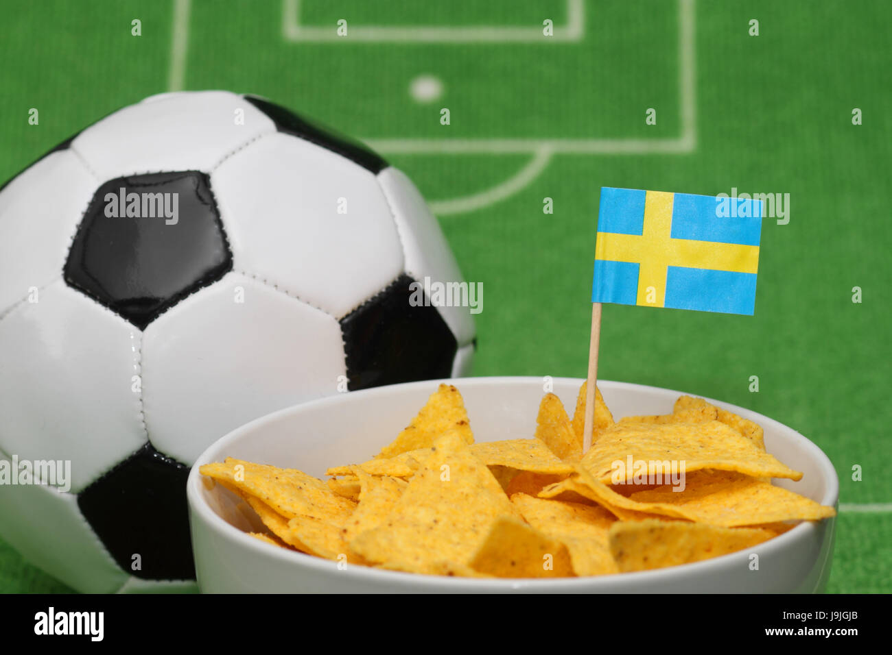 Soccer ball with crispy snacks in a bowl on green background Stock ...