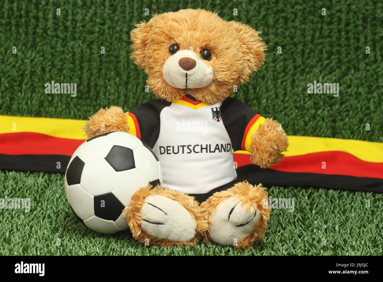 Teddy bear with football shirt on lawn background Stock Photo - Alamy