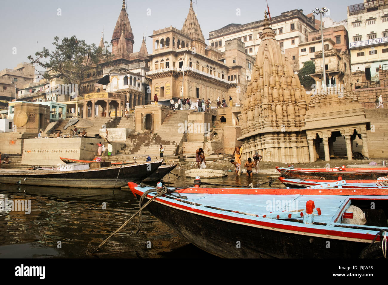 Ganges river boats and Hindu temples at the bathing ghats. Boats moored ...