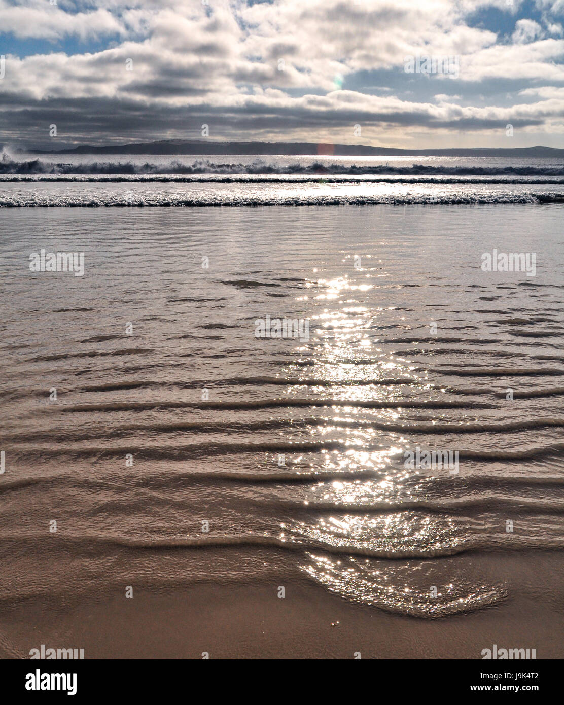 Sunny, pristine tidal beach with reflections and dramatic sky Stock ...