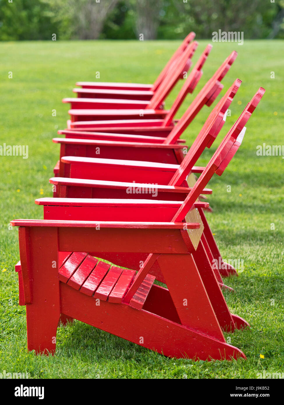Row of red wooden chairs Stock Photo - Alamy