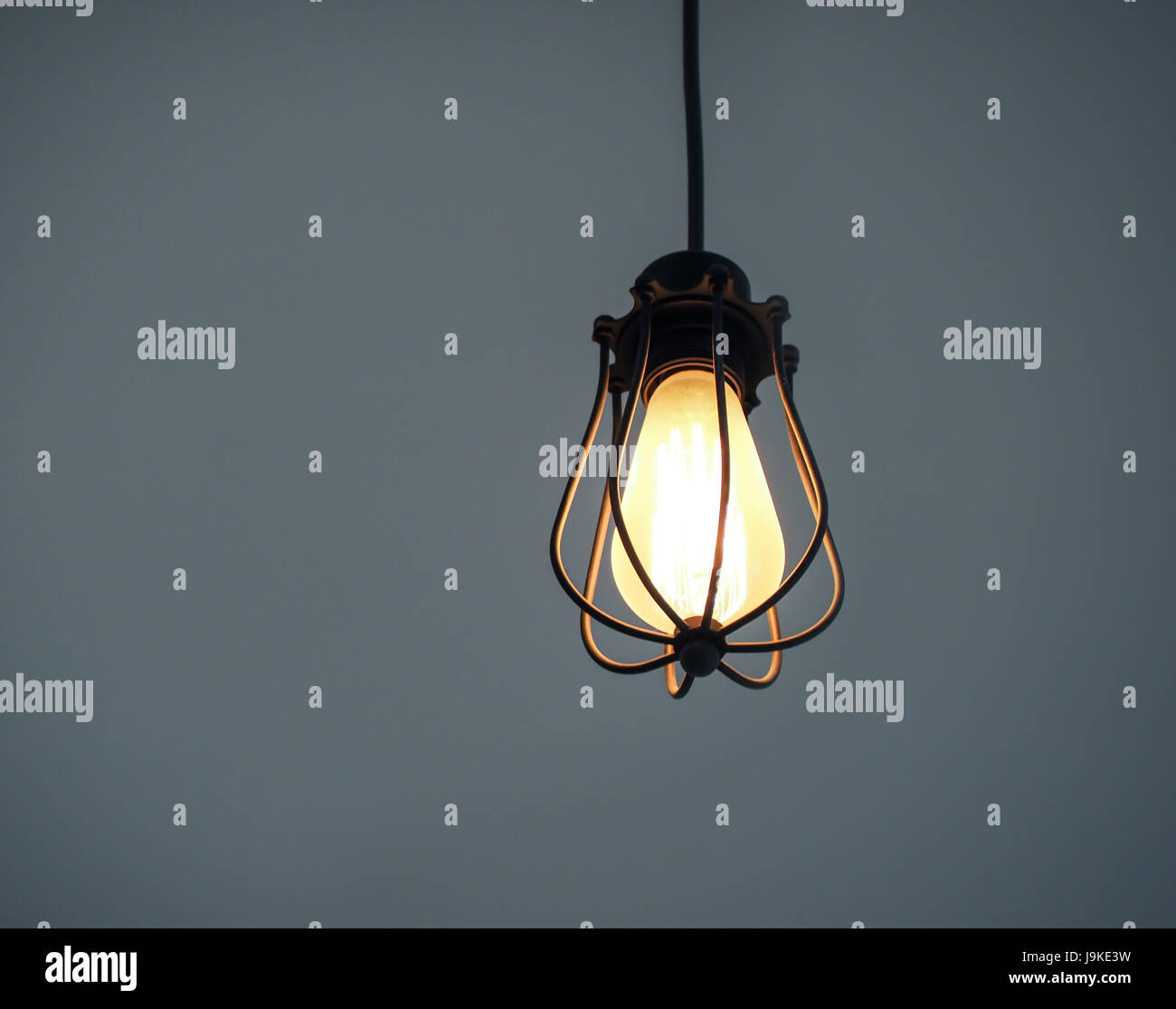 Yellow illuminated hanging light bulbs on plain navy background with ...