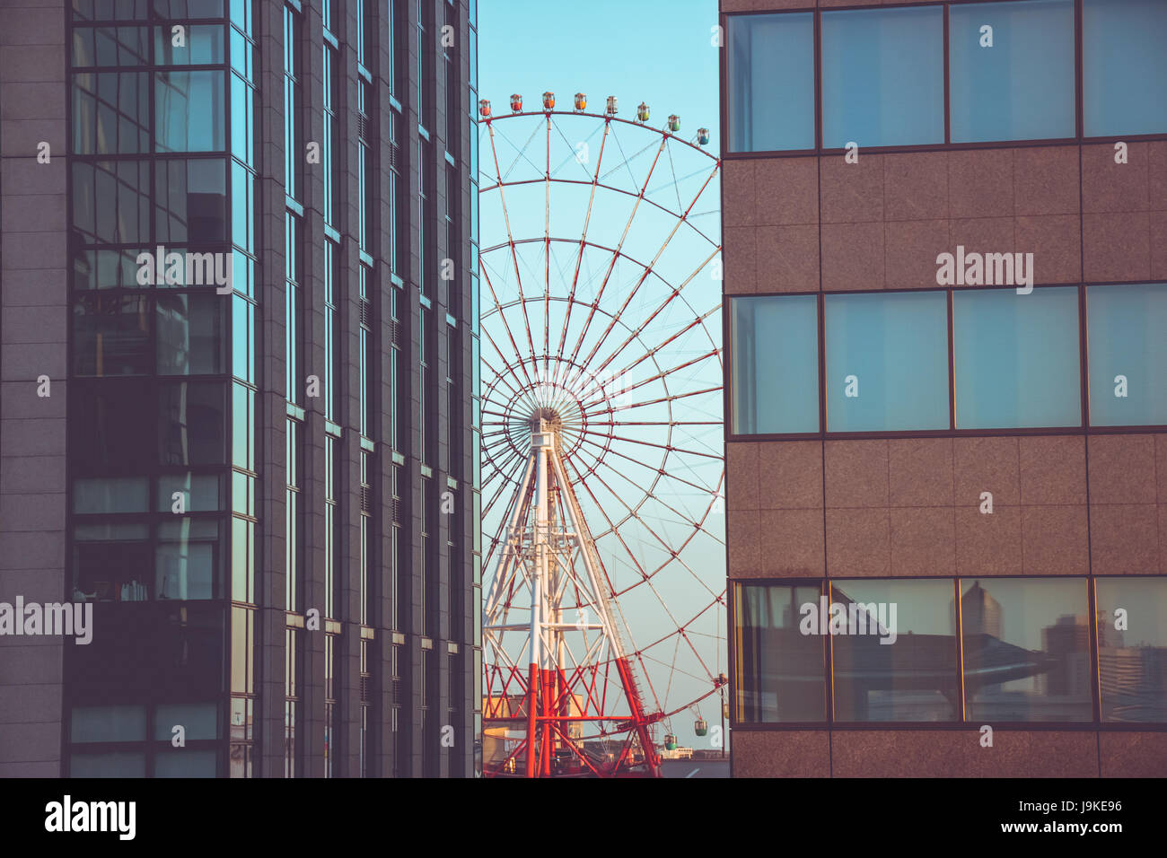 View of Ferris wheel between modern building in the town's pedestrian ...
