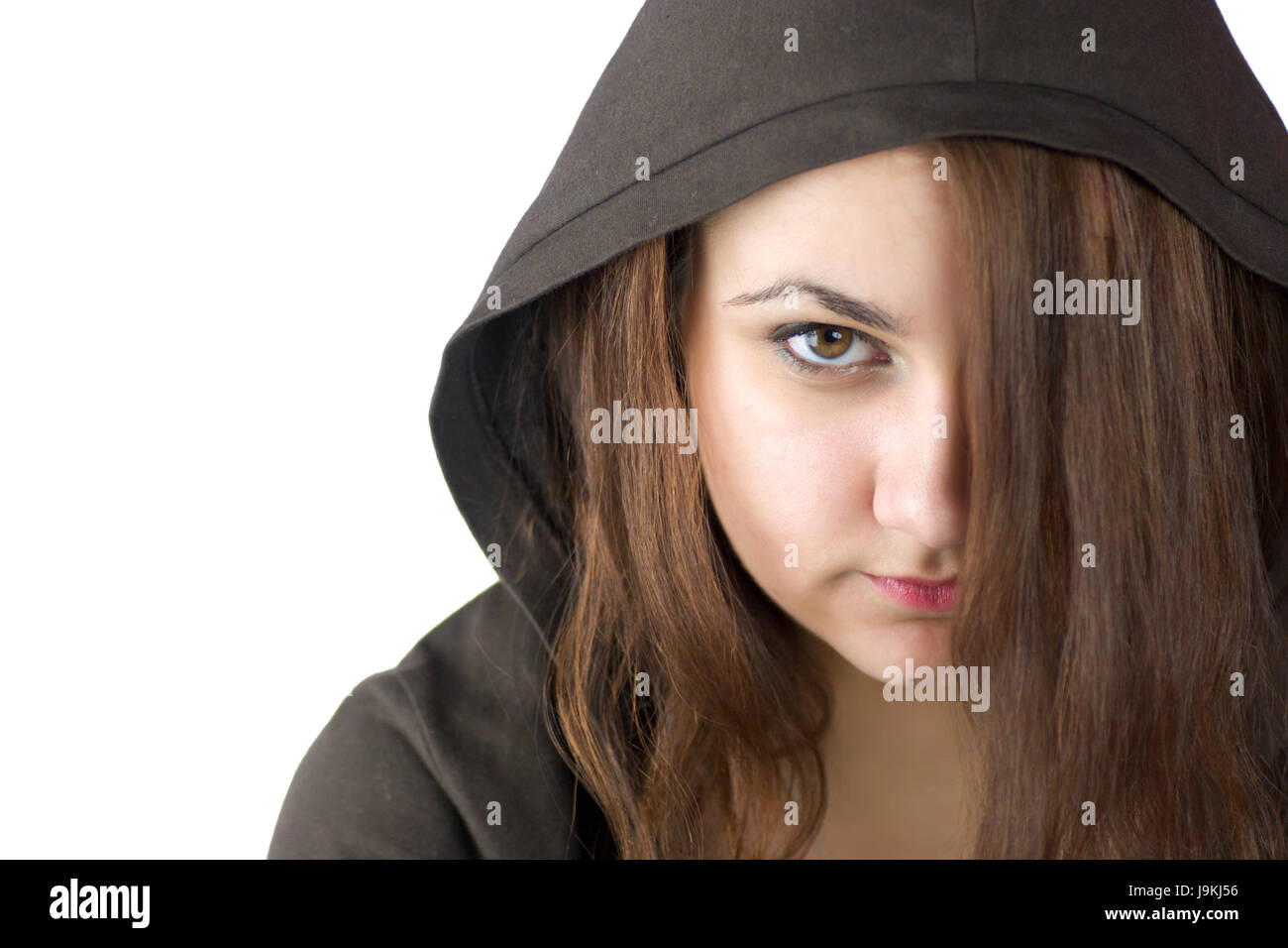 Angry Teenager with brown eyes wearing hood hiding face behing hair ...