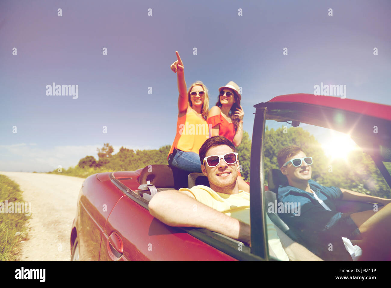 happy friends driving in cabriolet car at country Stock Photo - Alamy