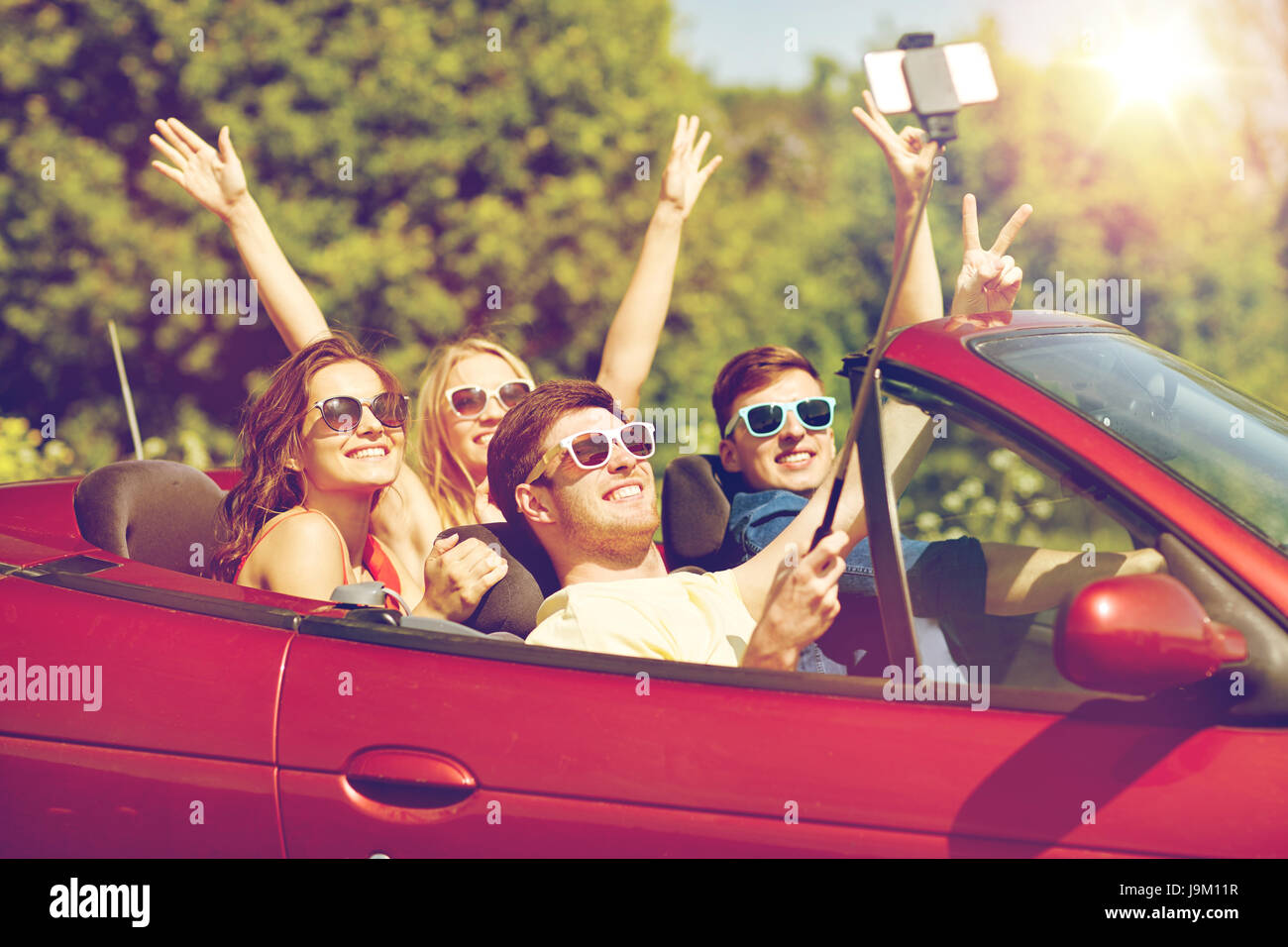 friends driving in cabriolet car and taking selfie Stock Photo - Alamy