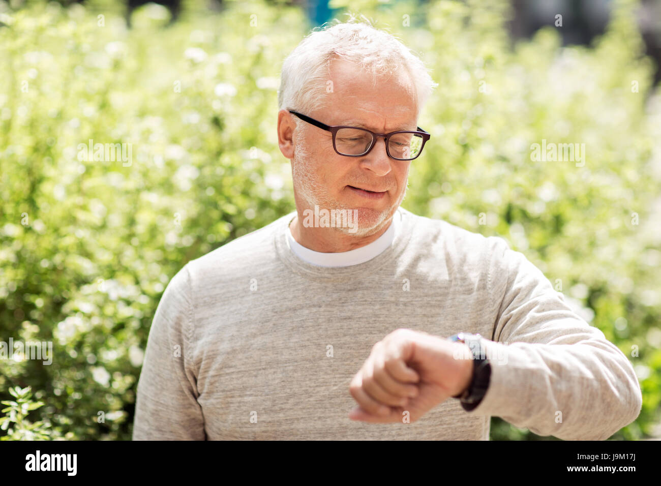 senior man checking time on his wristwatch Stock Photo - Alamy