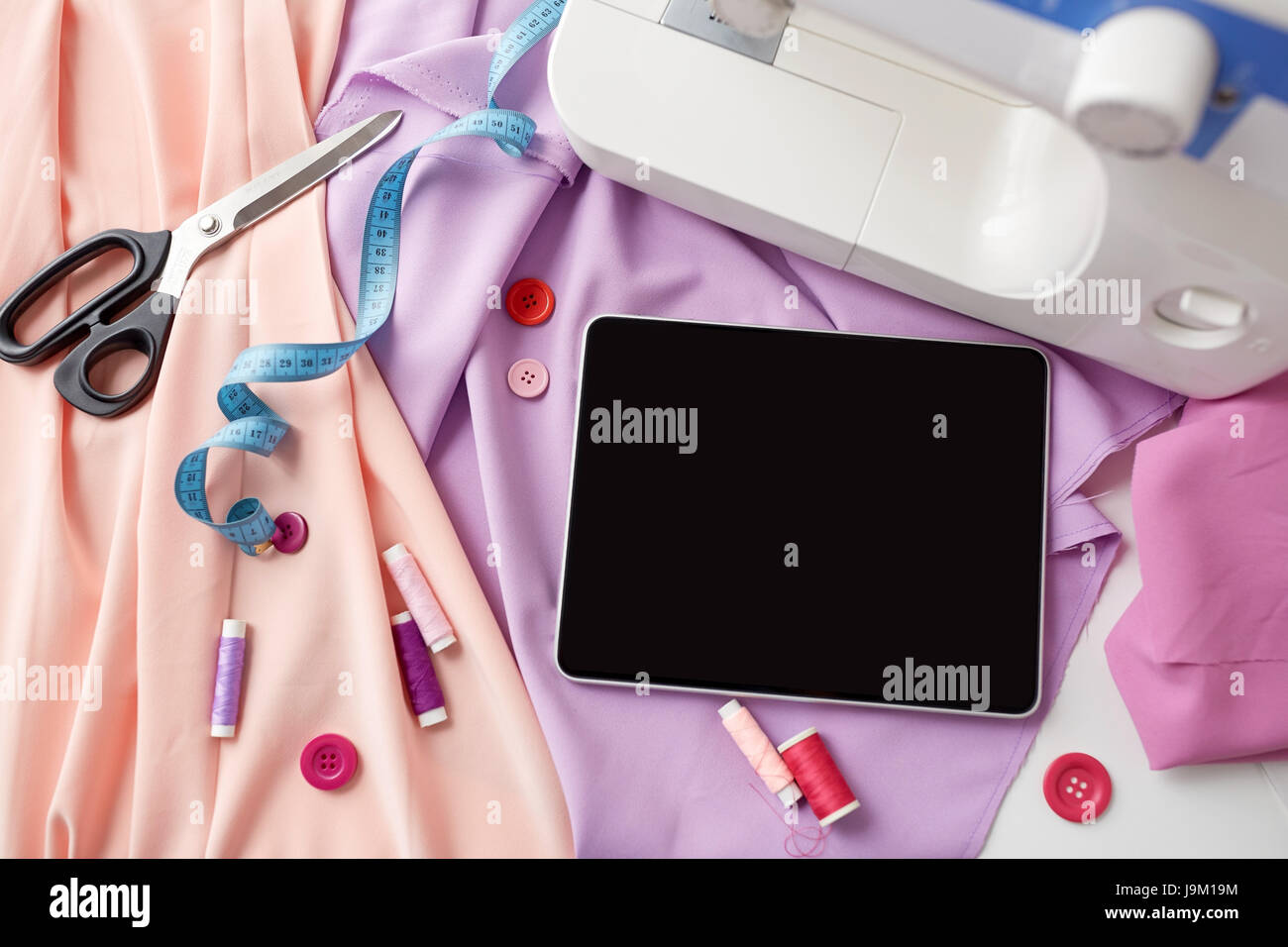 sewing machine, tablet pc, scissors and ruler Stock Photo - Alamy