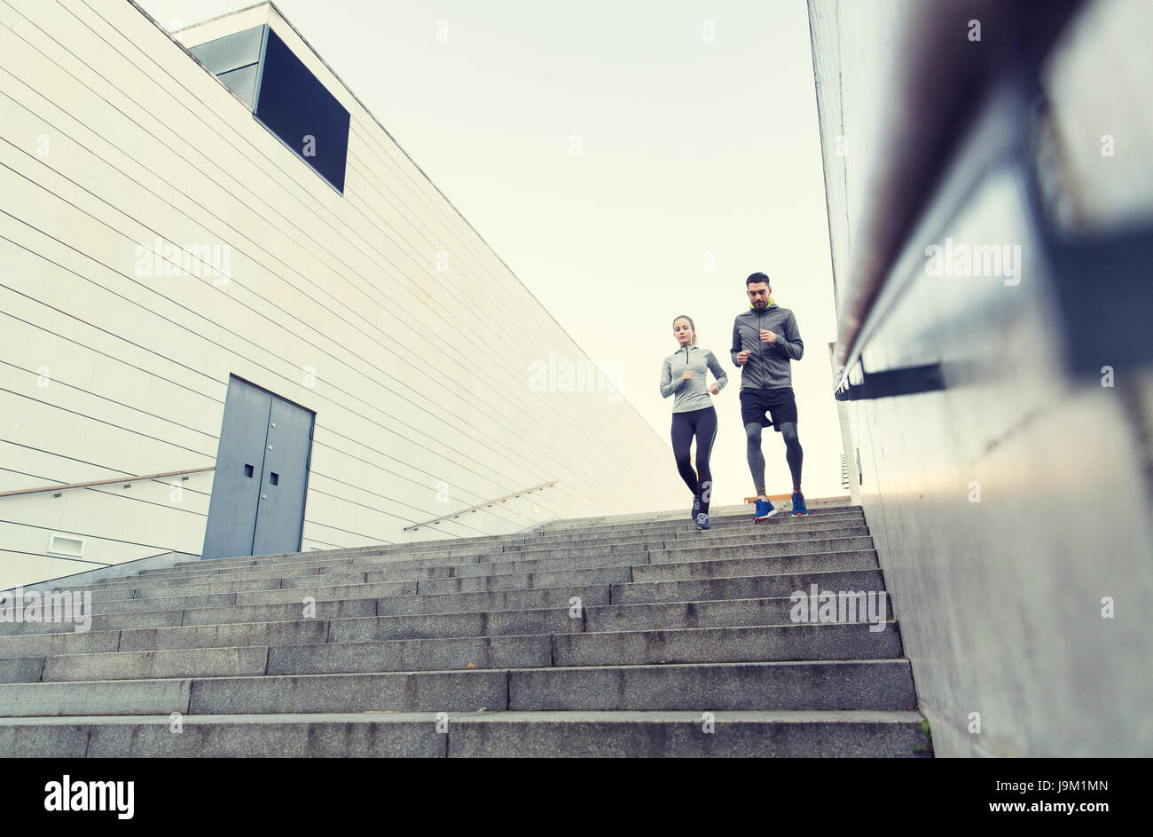couple running downstairs on city stairs Stock Photo - Alamy