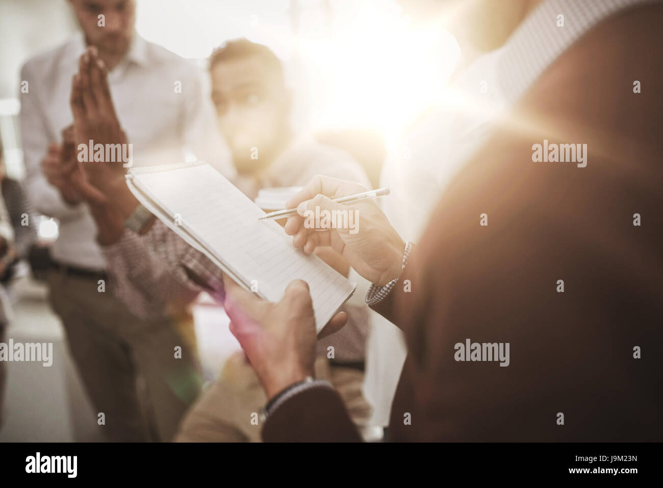 business team and man writing to notepad at office Stock Photo - Alamy