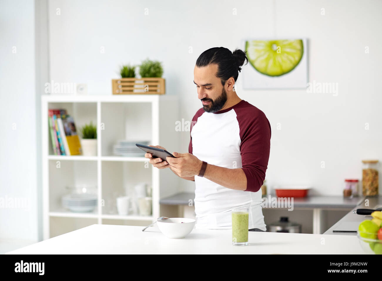 man with tablet pc eating breakfast at home Stock Photo - Alamy