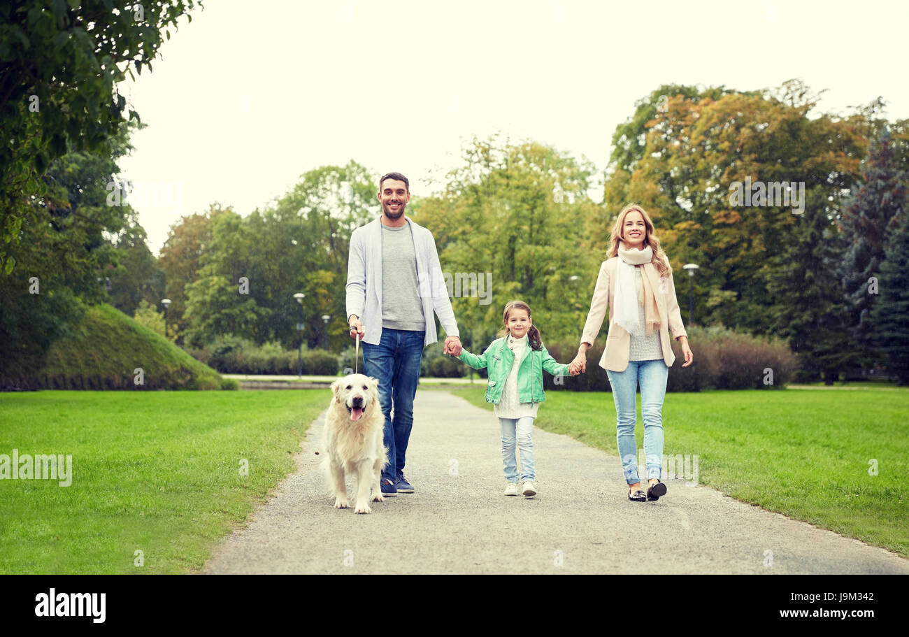 happy family with labrador retriever dog in park Stock Photo - Alamy