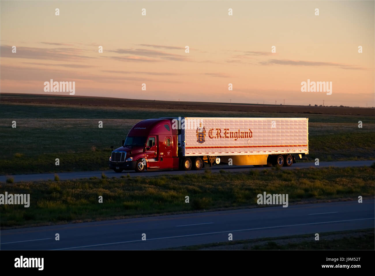 A Red Freightliner Semi-Truck Pulls a White "C.R. England" Trailer ...