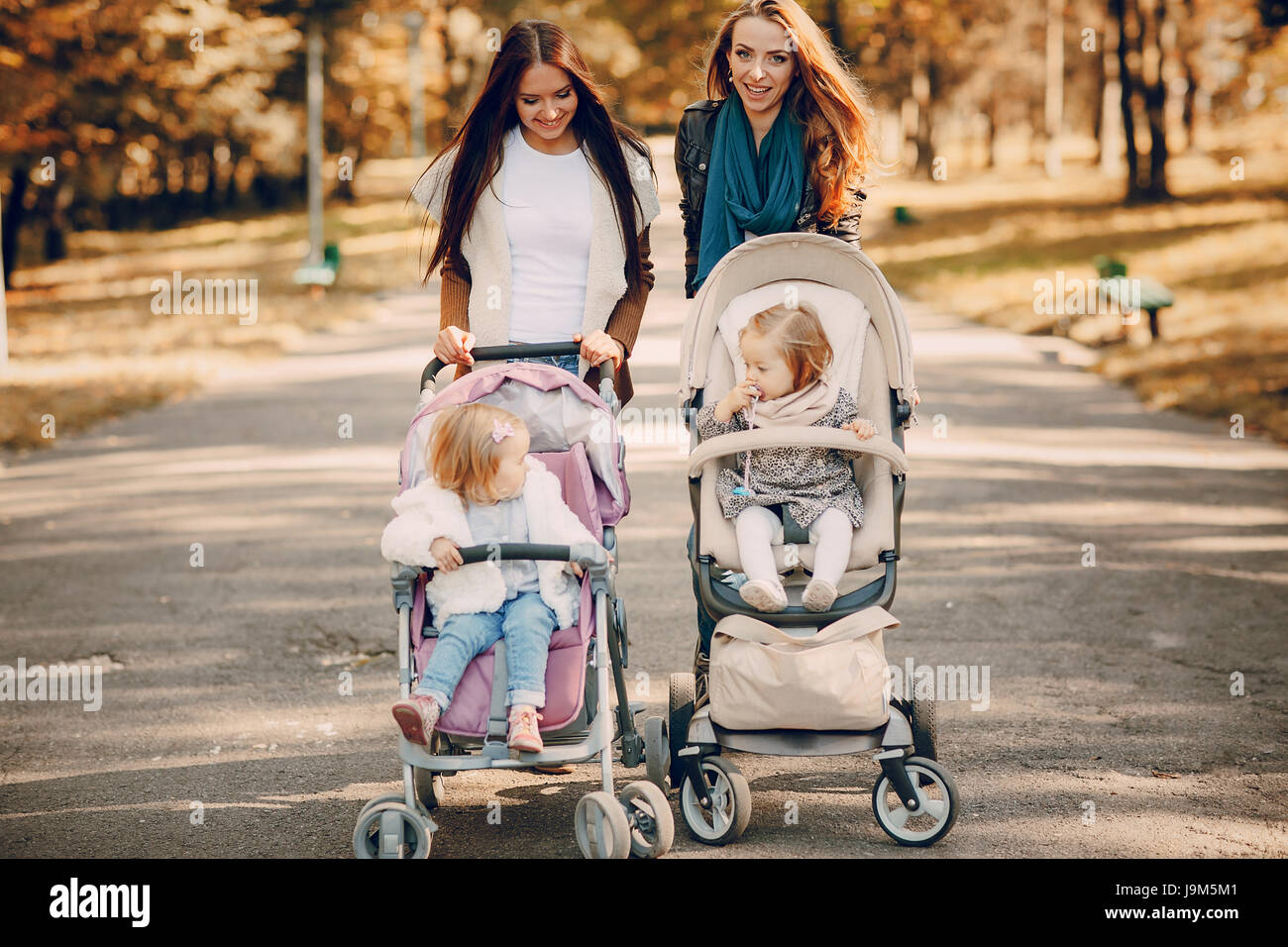 young mother walking with her baby and carries it in a beautiful pram ...