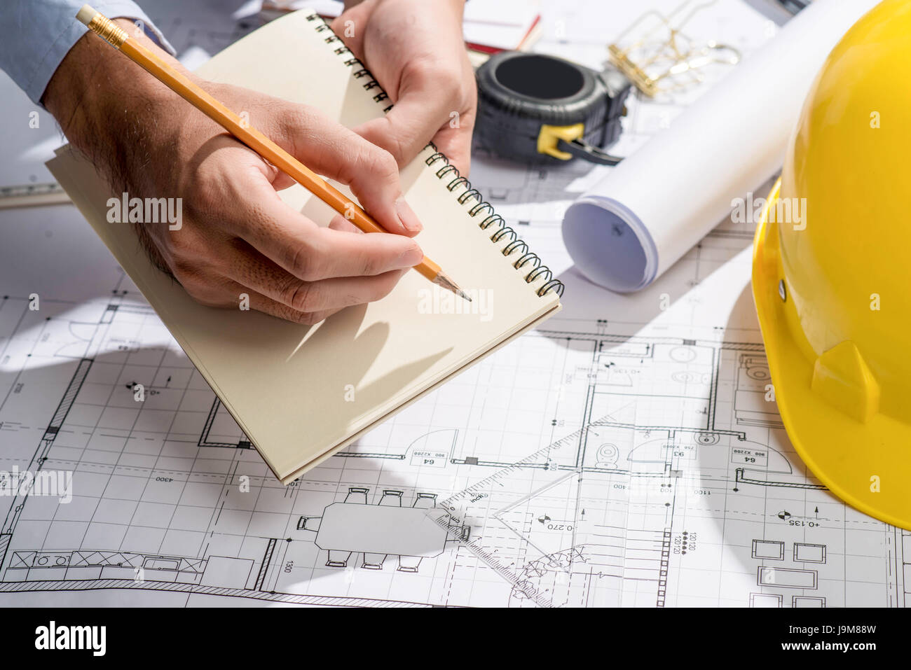 Working on blueprints. Construction project with hands writing on ...