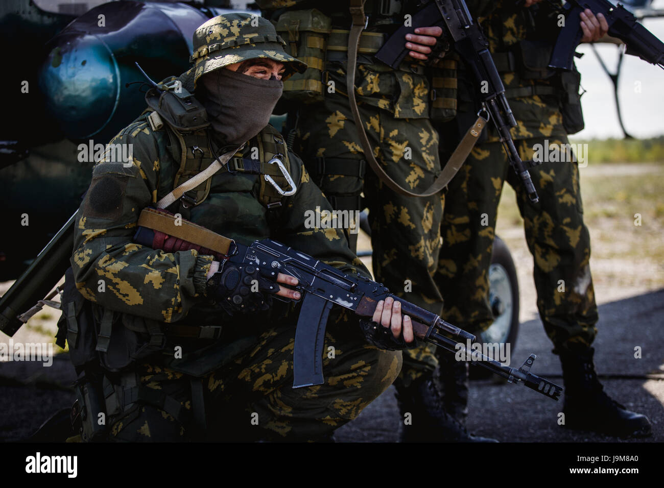 Photos of a group of military men with a gun in front of a helicopter ...