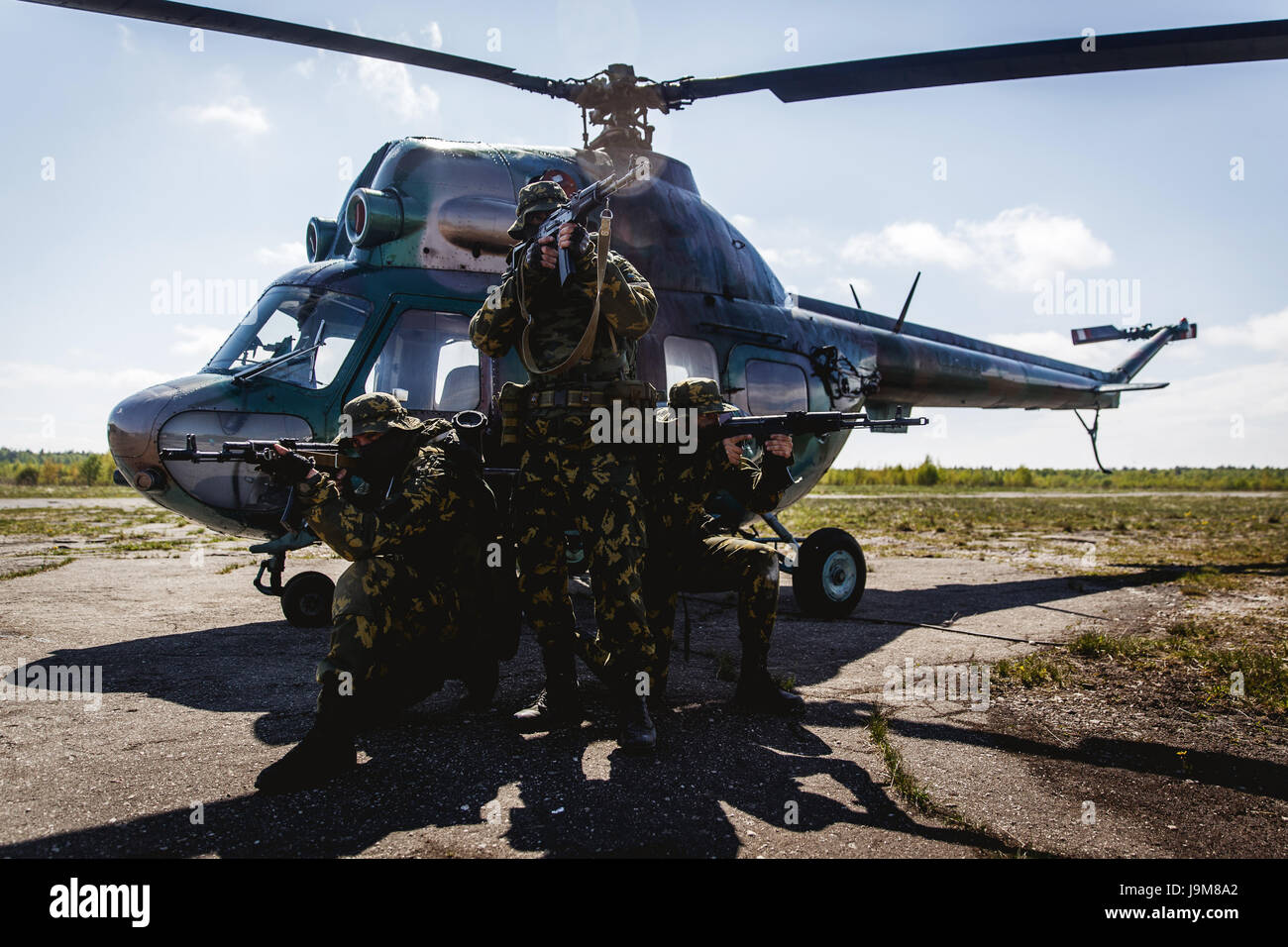 Photos of a group of military men with a gun in front of a helicopter ...