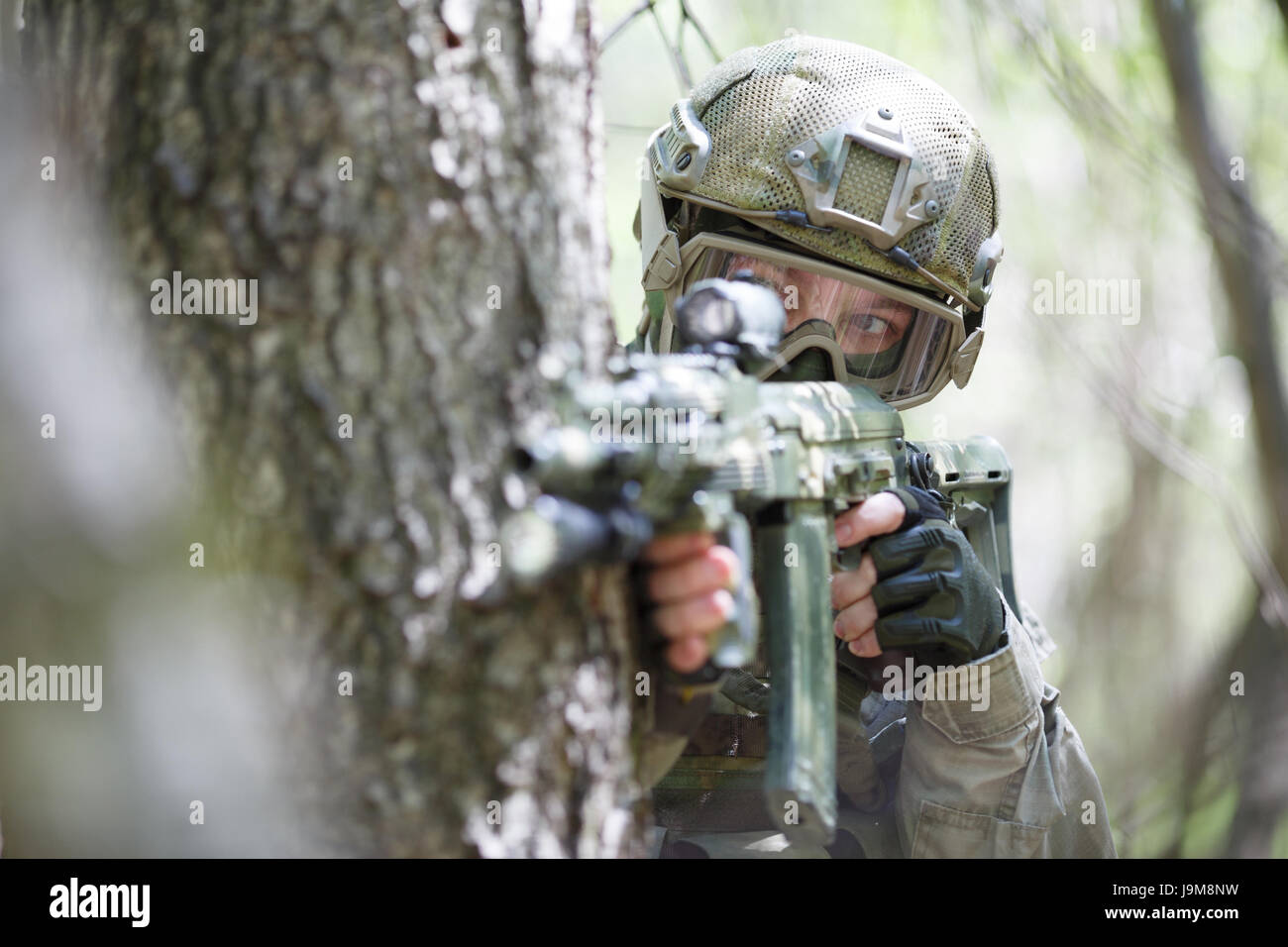 Sniper with rifle in forest Stock Photo - Alamy