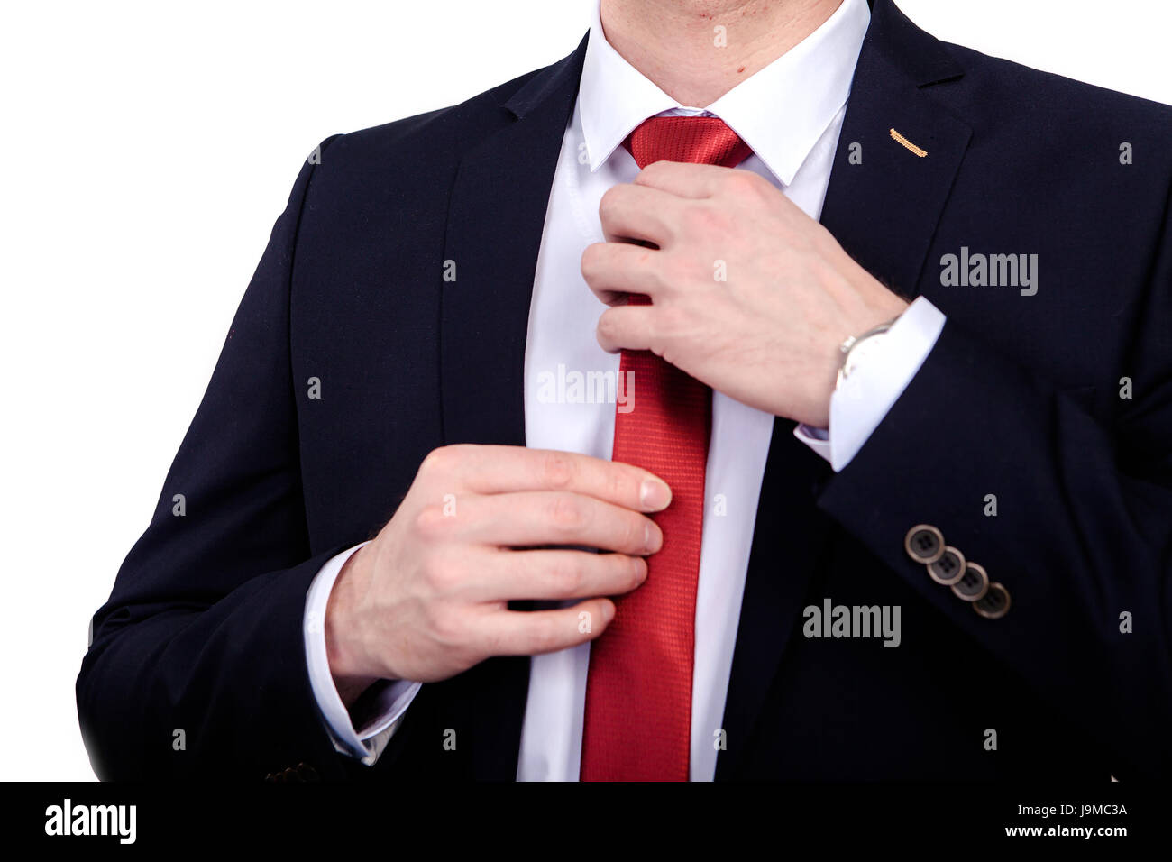 The banker corrects the red tie, with his hands, on his neck on a white ...
