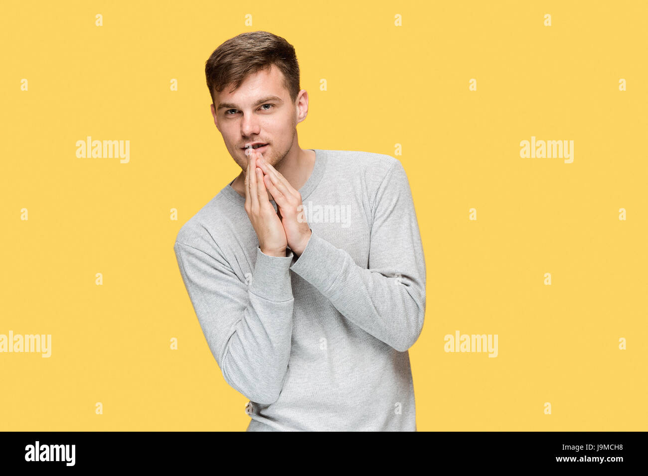 The young serious man looking cautiously and Speaking secret Stock ...