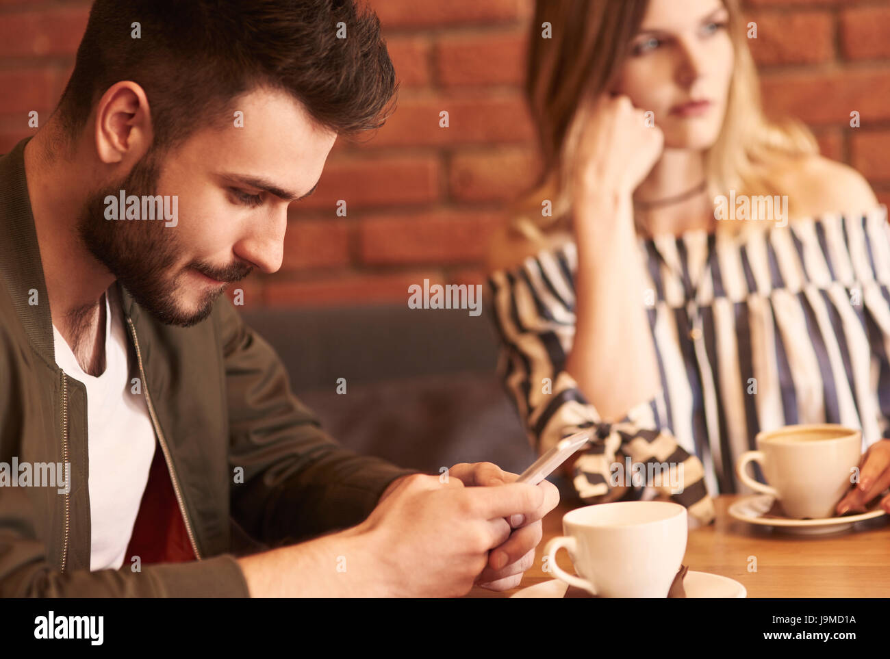 Man using cell phone over meeting with girlfriend Stock Photo - Alamy