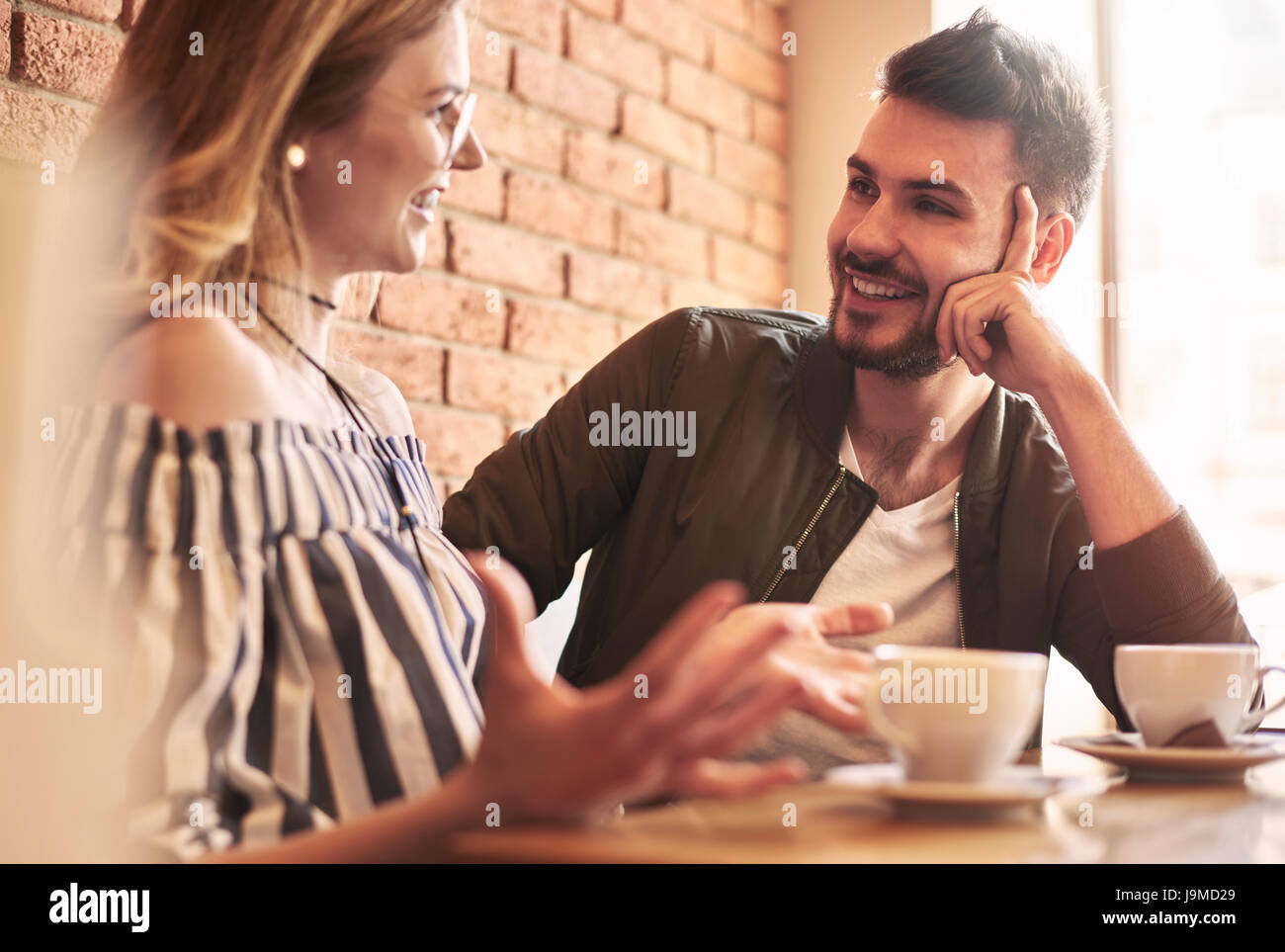 Young couple having conversation over coffee break Stock Photo - Alamy
