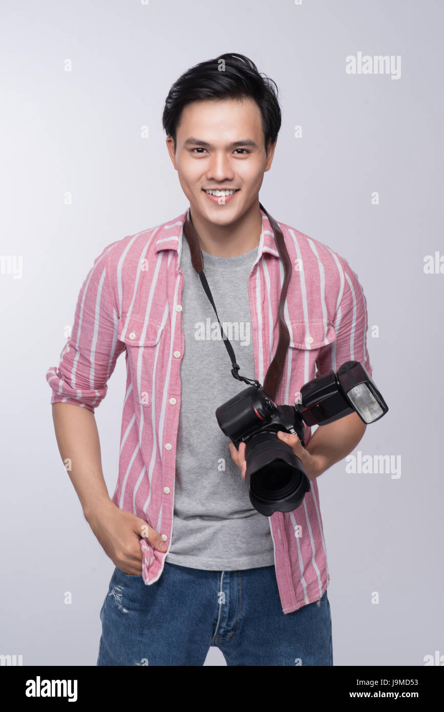 Young asian photographer holding digital camera, while working in ...