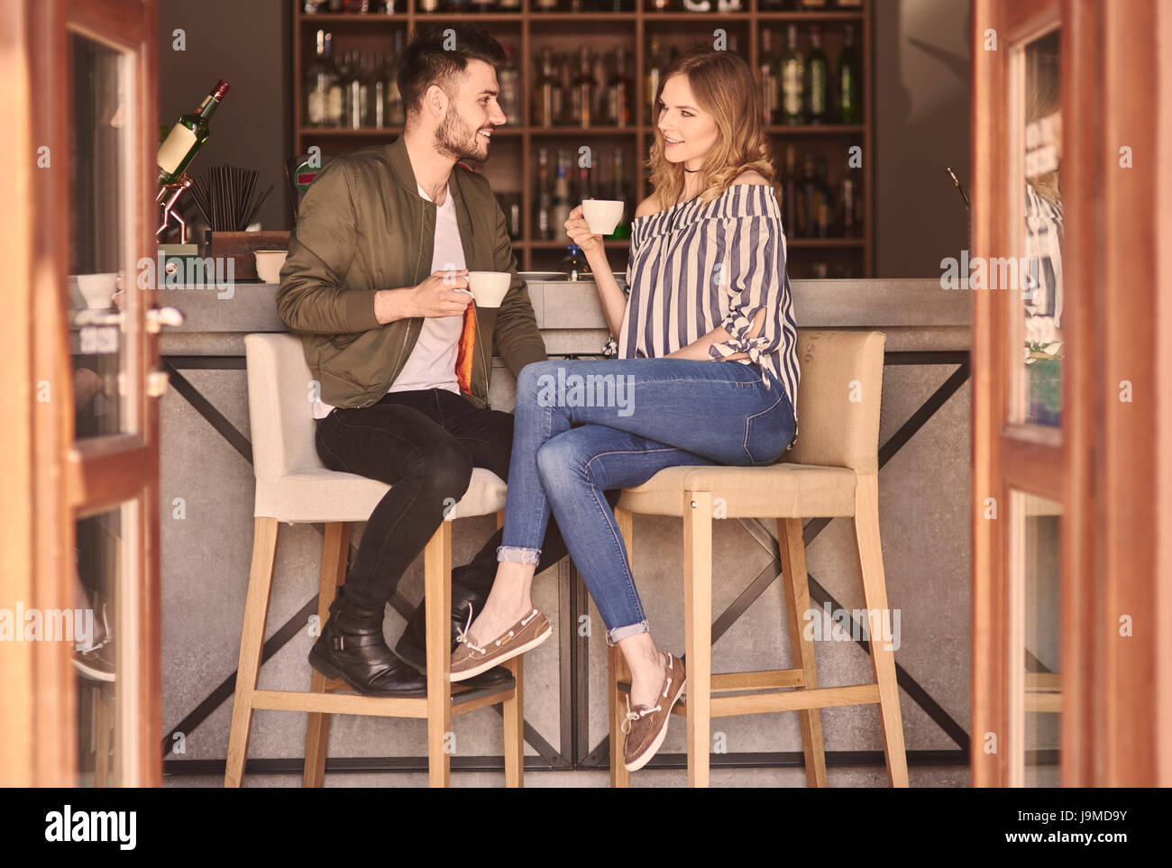 Full length of couple at bar counter Stock Photo - Alamy