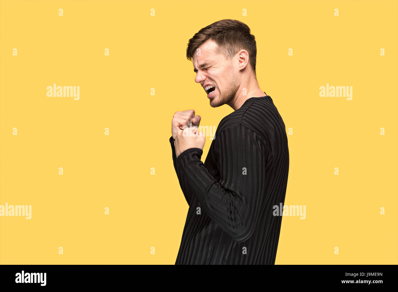 The young man with a raised fist Stock Photo - Alamy