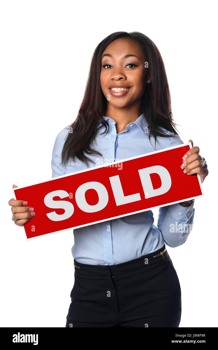 African American woman holding Sold sign in front of house Stock Photo ...