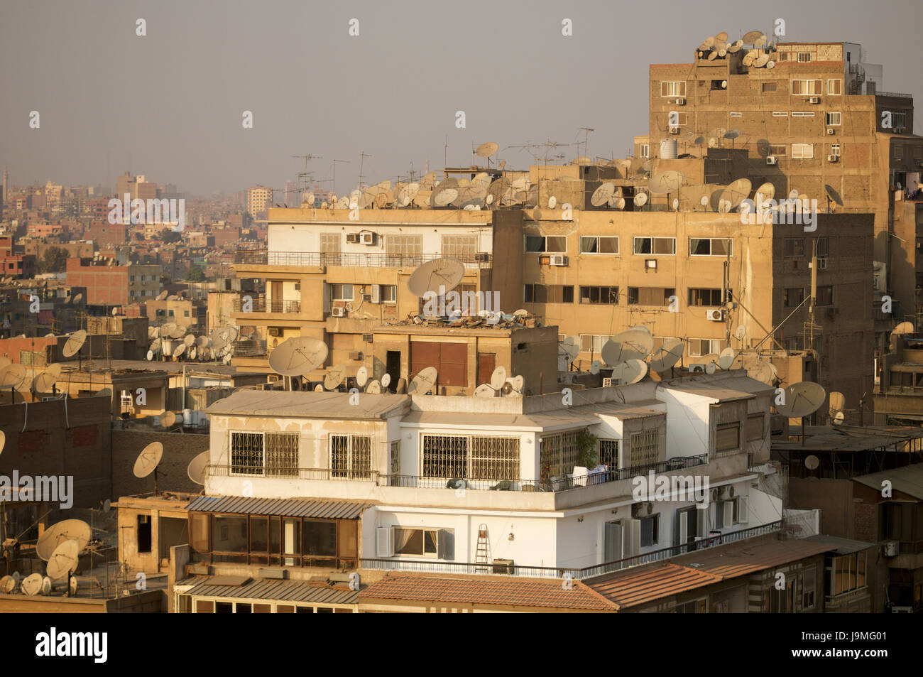 Clusters of satellite dishes compete for space atop buildings in Cairo ...
