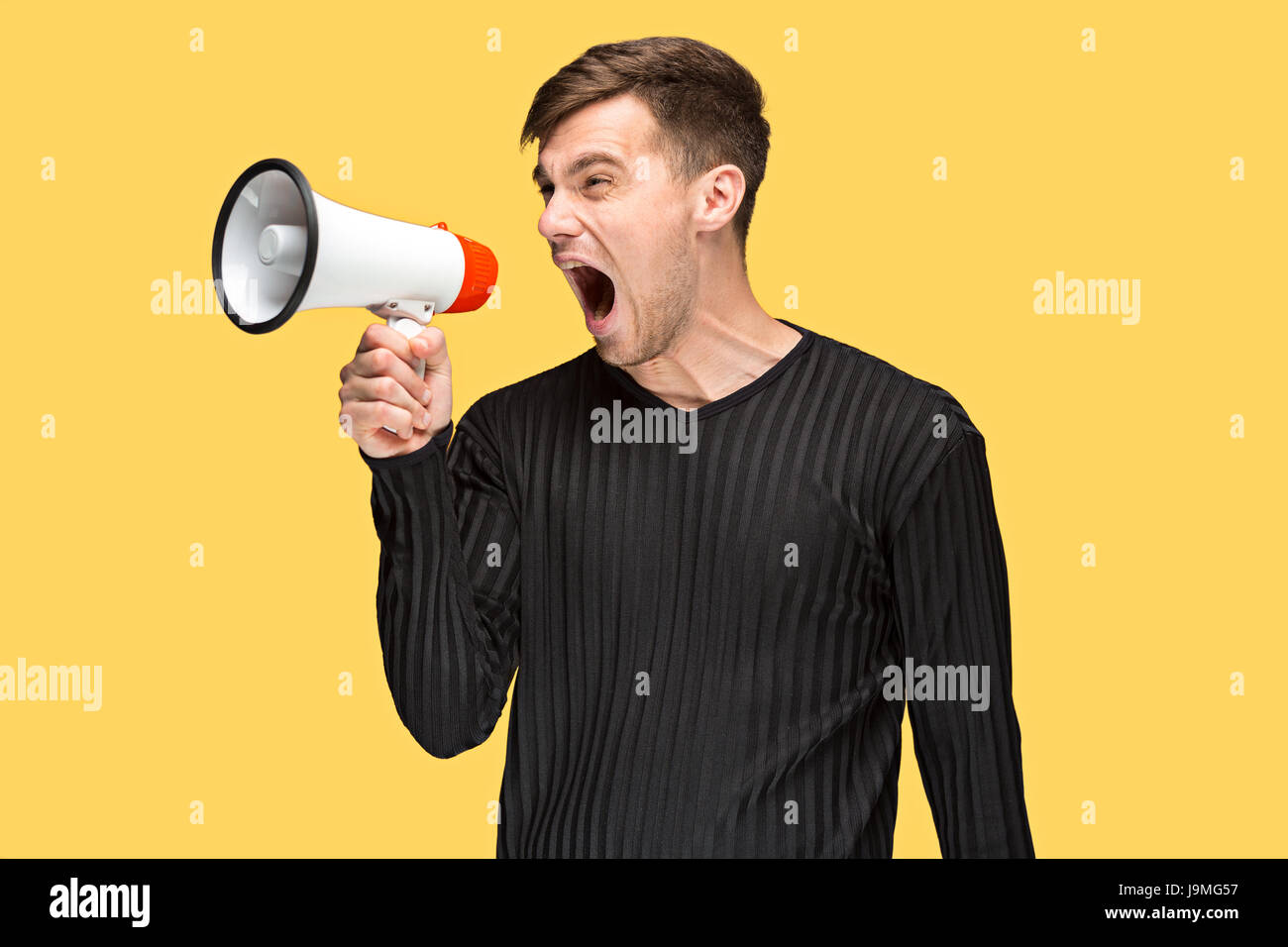 The young man holding a megaphone Stock Photo - Alamy