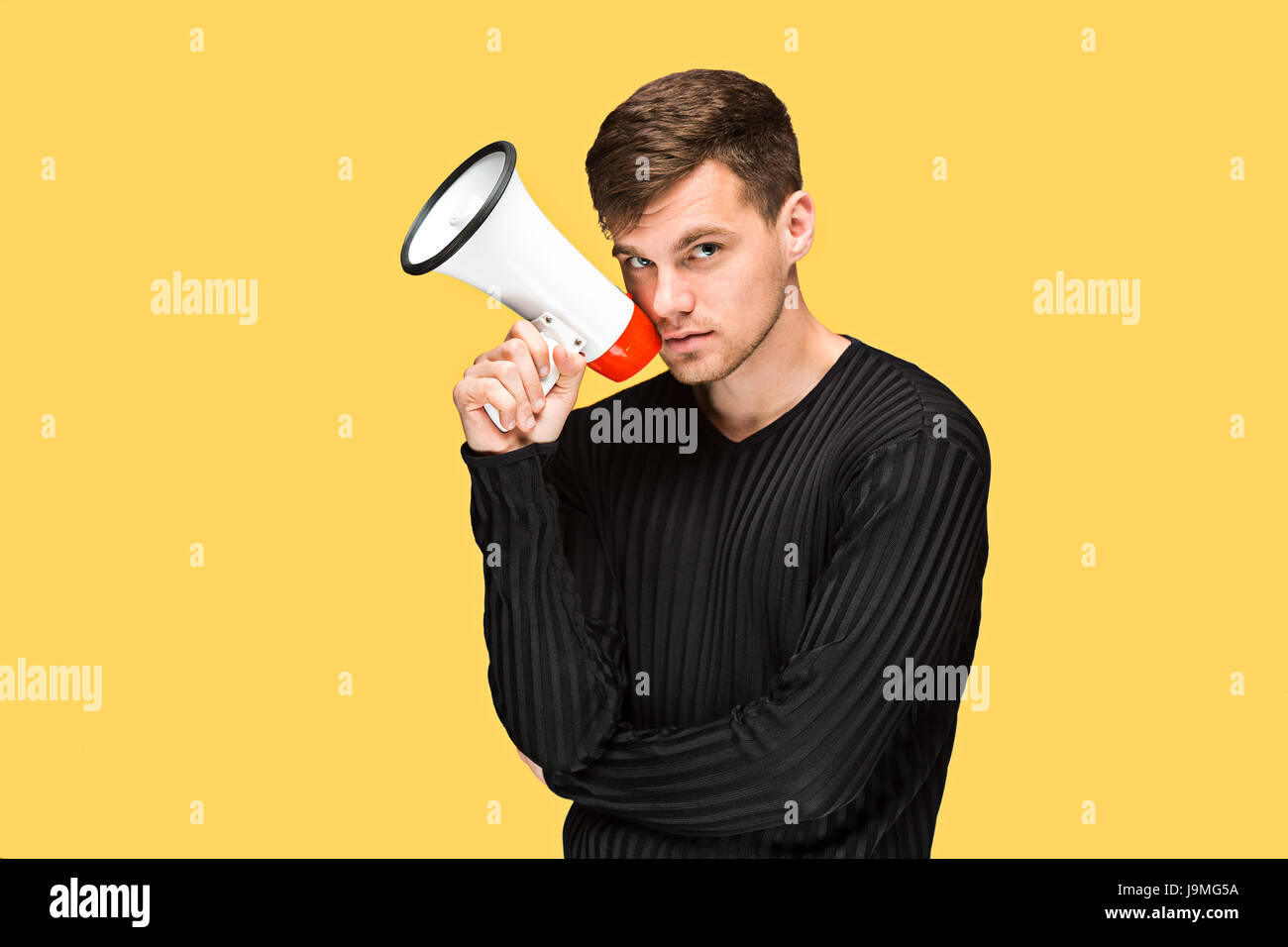 The young man holding a megaphone Stock Photo - Alamy