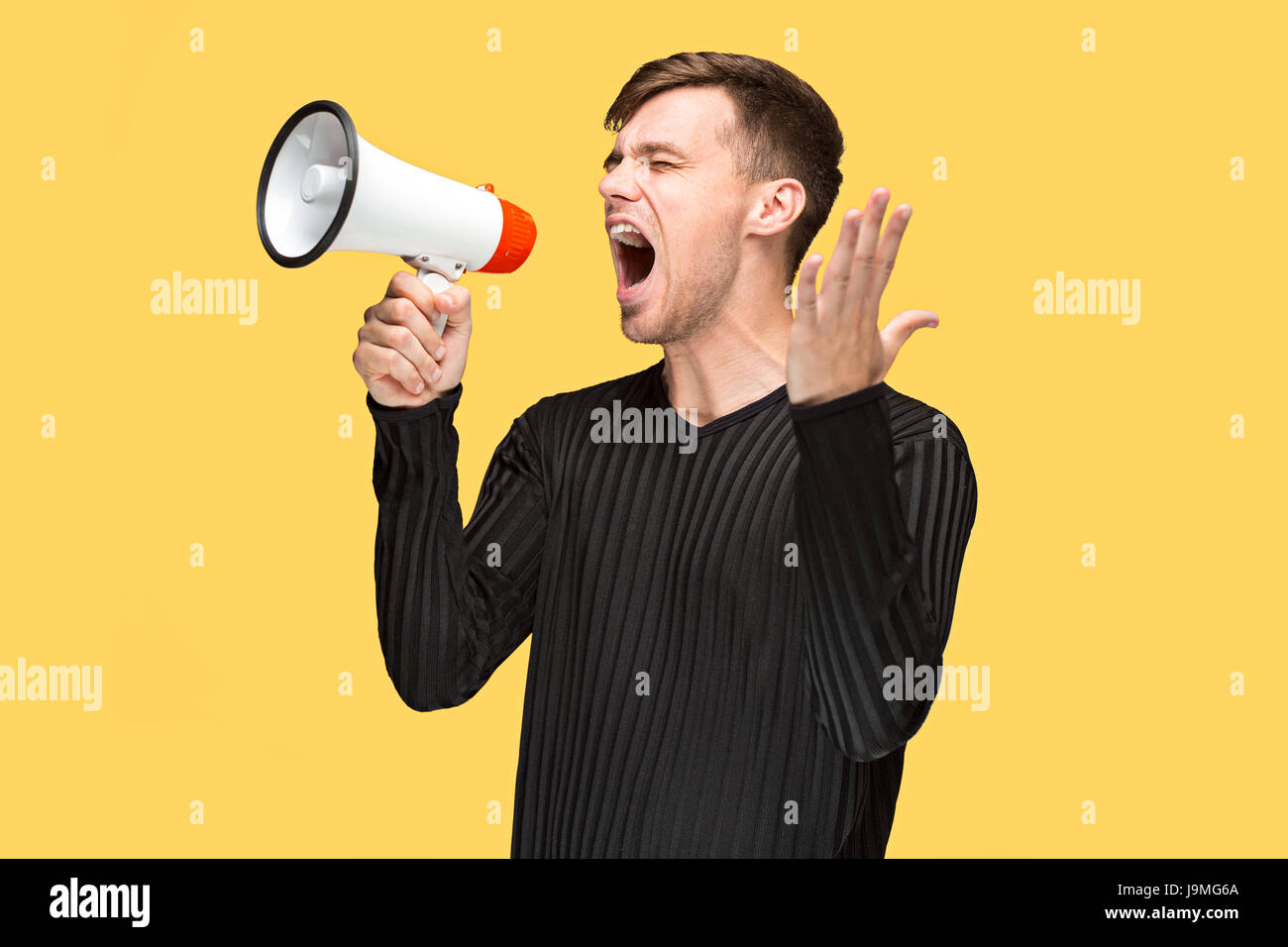 The young man holding a megaphone Stock Photo - Alamy