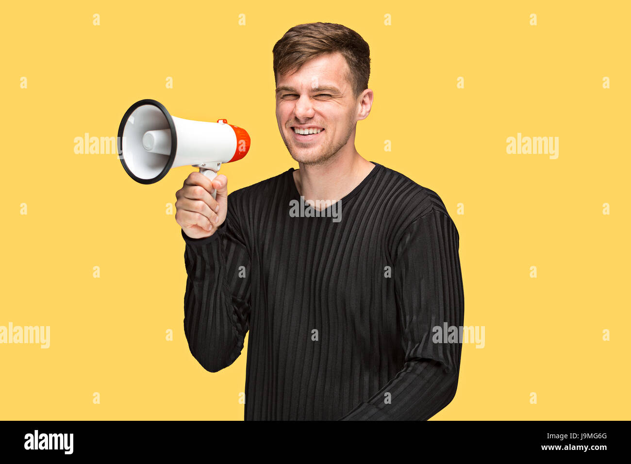 The young man holding a megaphone Stock Photo - Alamy