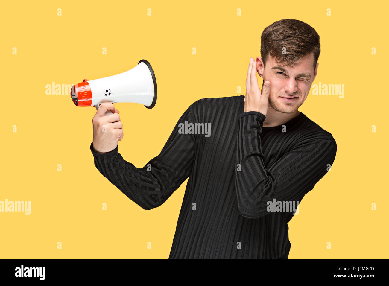 The young man holding a megaphone Stock Photo - Alamy