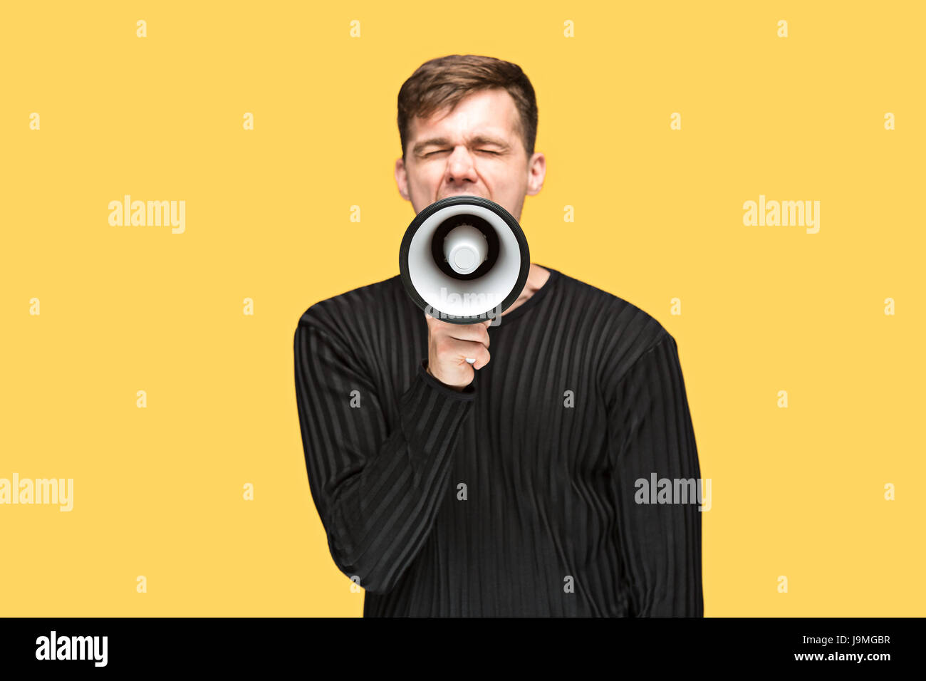 The young man holding a megaphone Stock Photo - Alamy