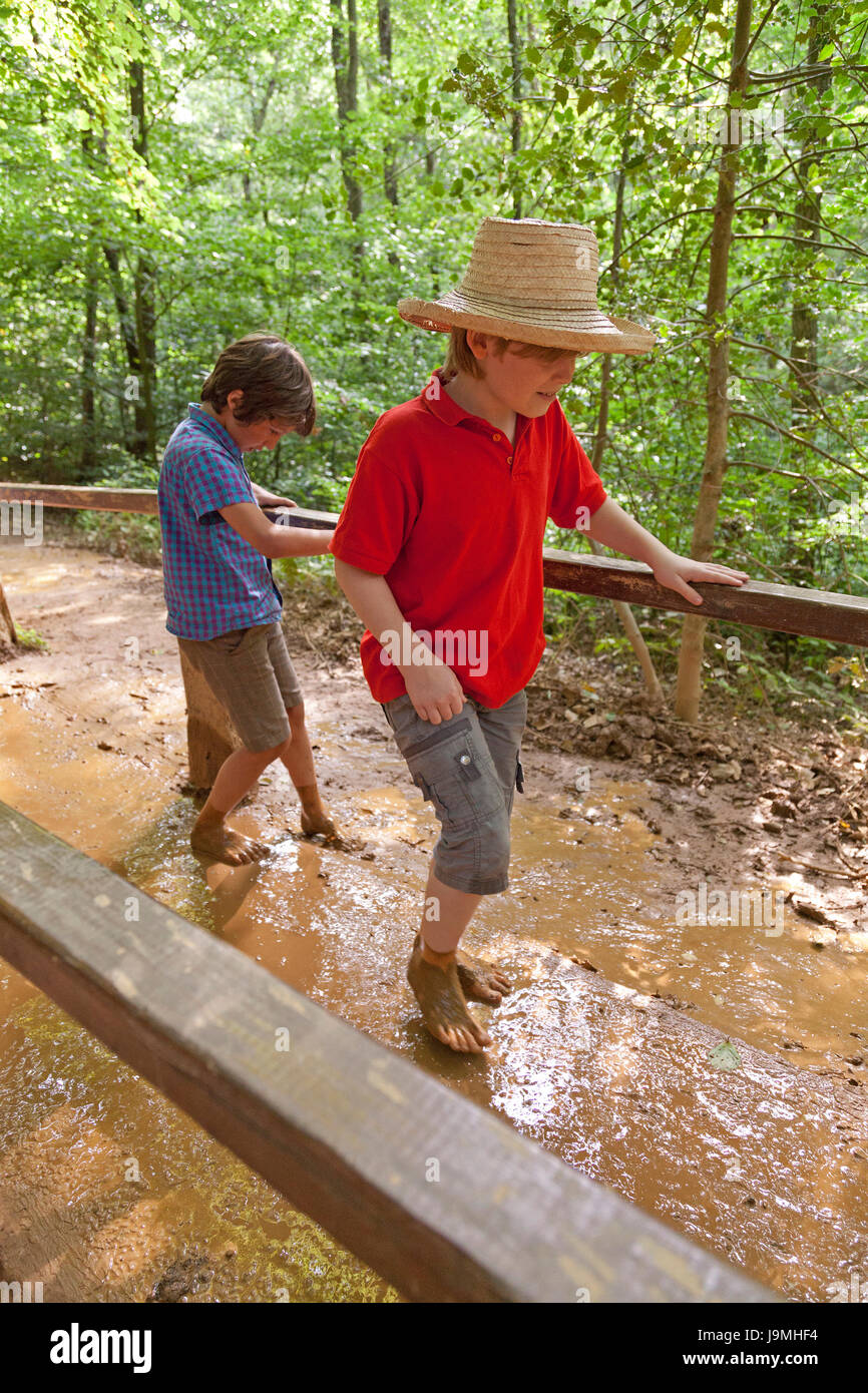 boys walking through mud at barefoot trail, Egestorf, Lower-Saxony ...