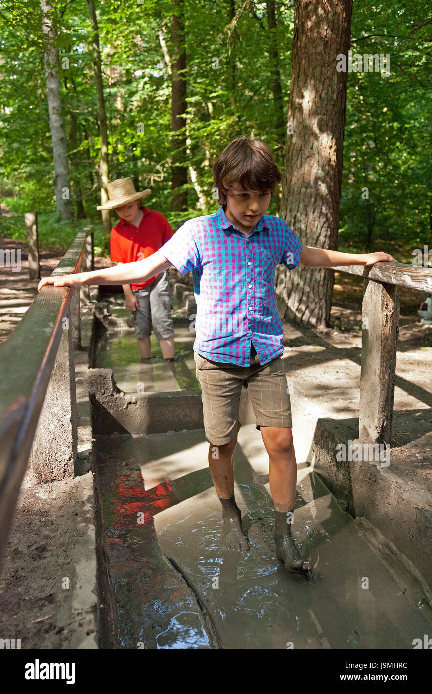 boys walking through mud at barefoot trail, Egestorf, Lower-Saxony ...