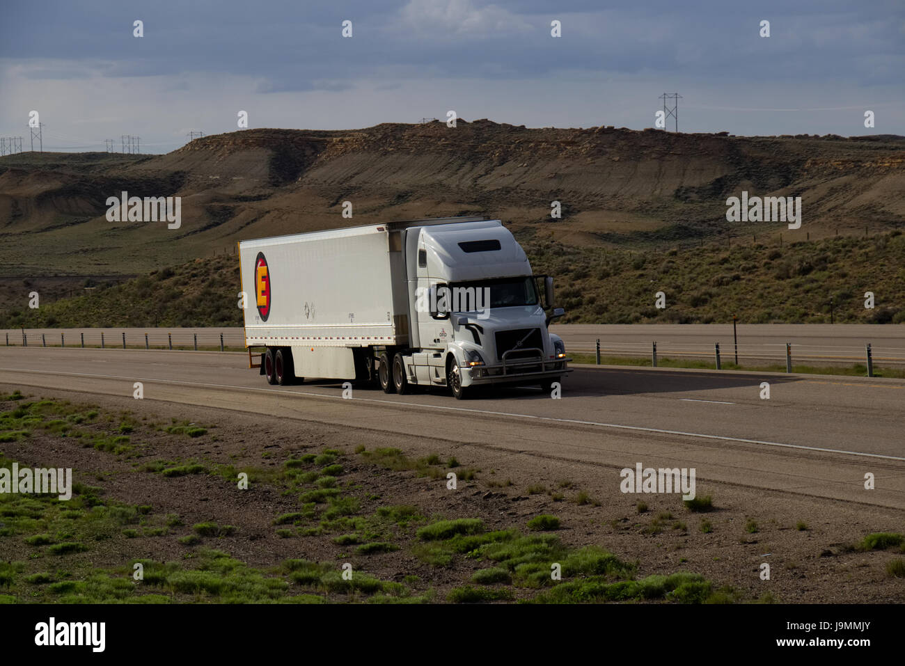 White Volvo Semi-Truck Pulling a White Estes Trailer along a Rural US ...