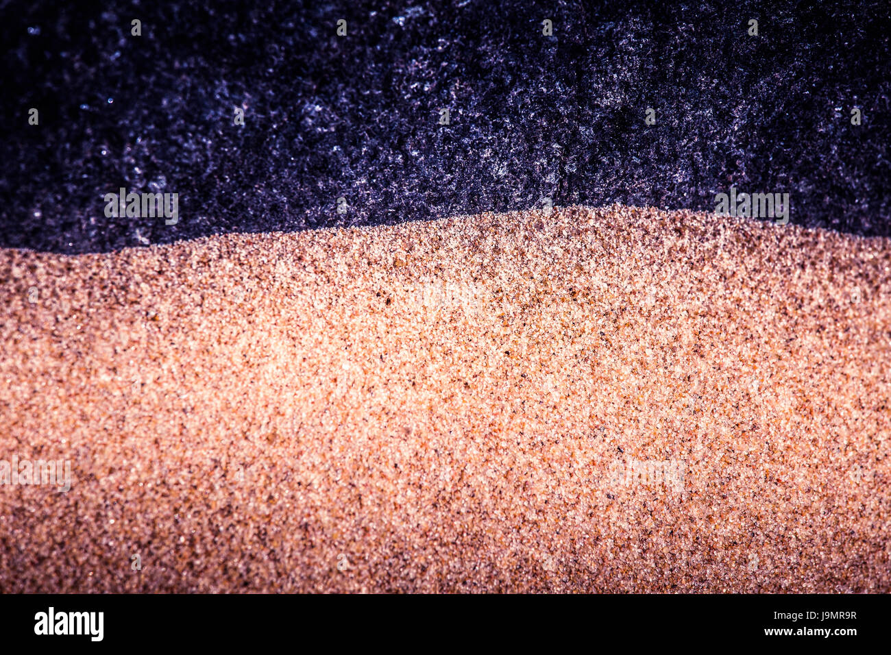 An abstract, high contrast background of a sea sand and rock shapes ...
