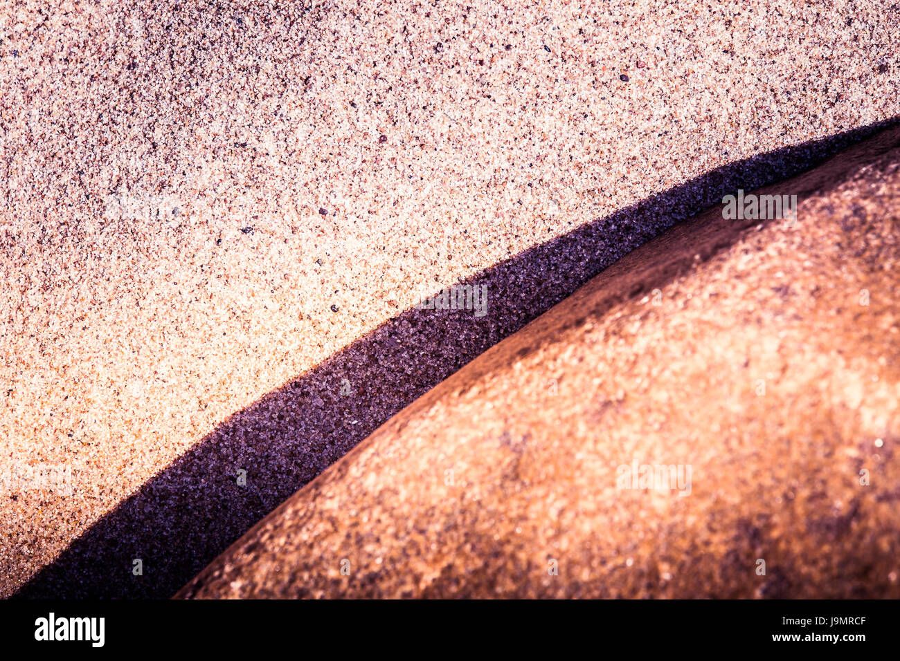 An abstract, high contrast background of a sea sand and rock shapes ...