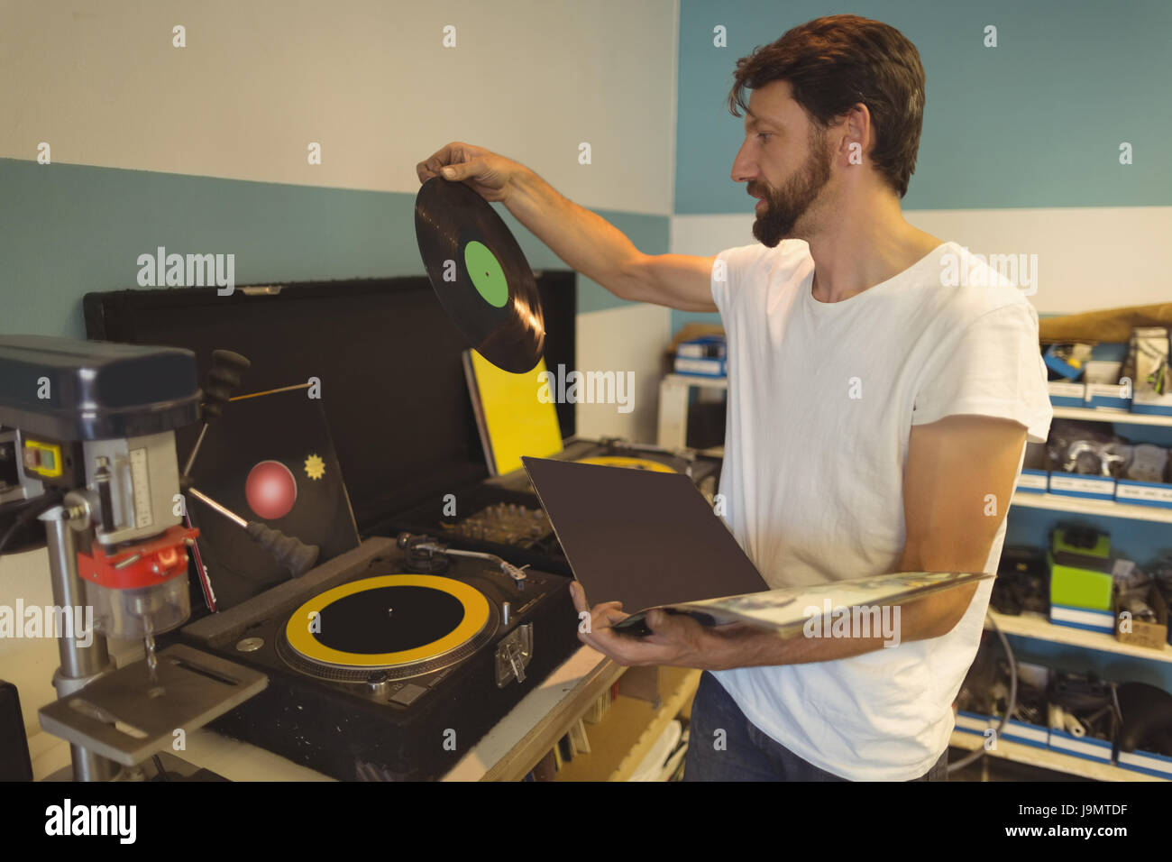 Worker holding record by turntable at bicycle workshop Stock Photo - Alamy